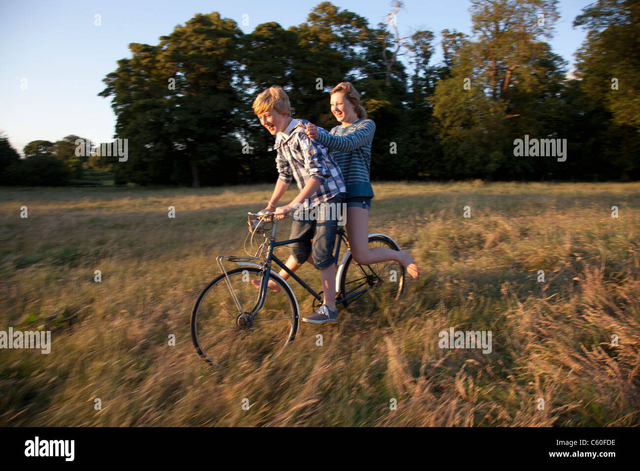 Teenage couple riding bicycle together Stock Photo - Alamy
