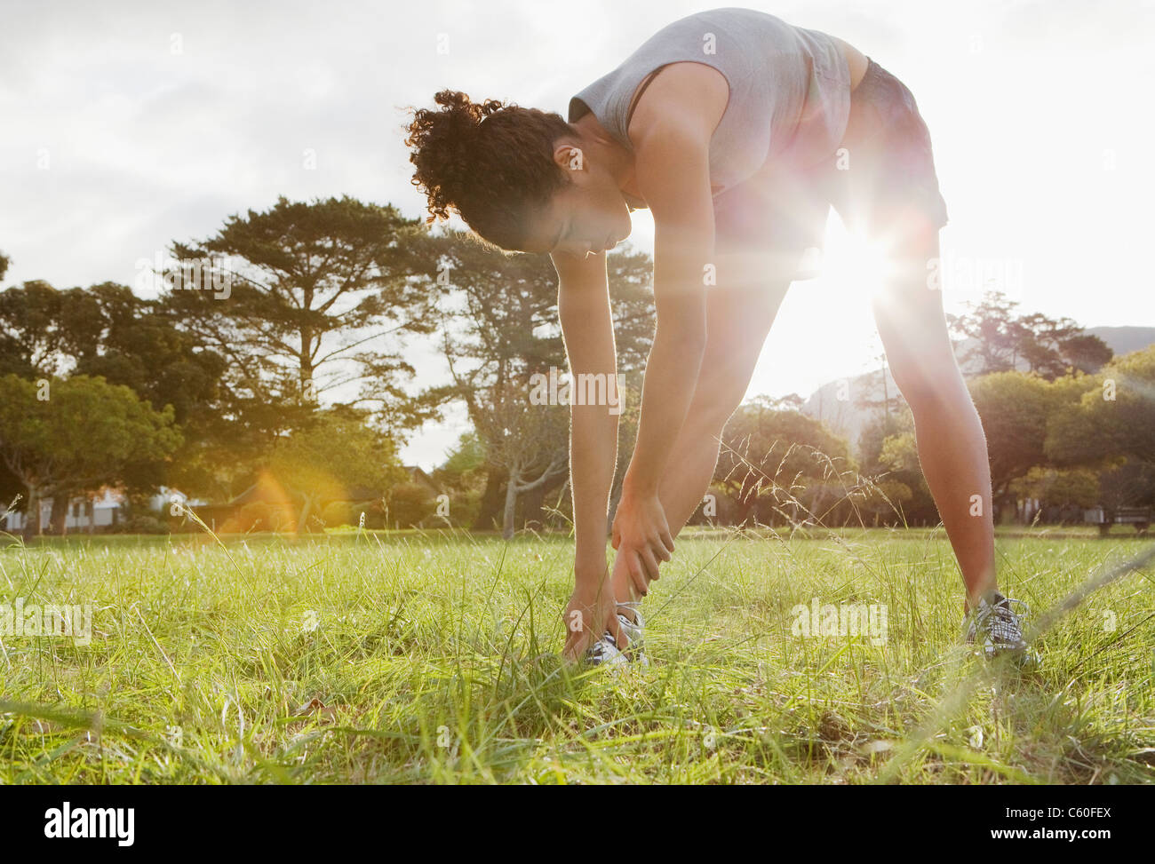 Runner stretching in field Stock Photo - Alamy