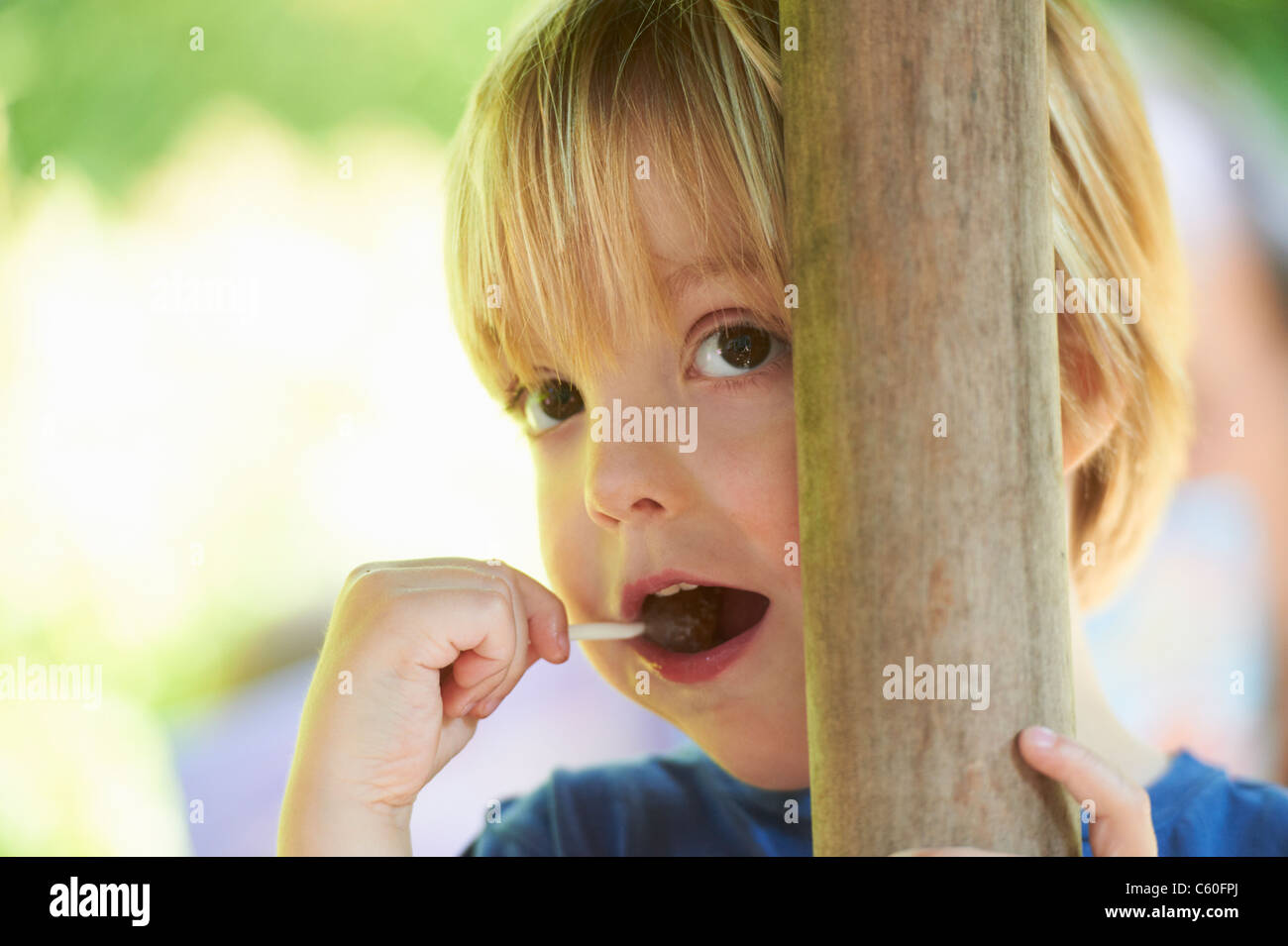 Boy sucking on lollipop Stock Photo - Alamy