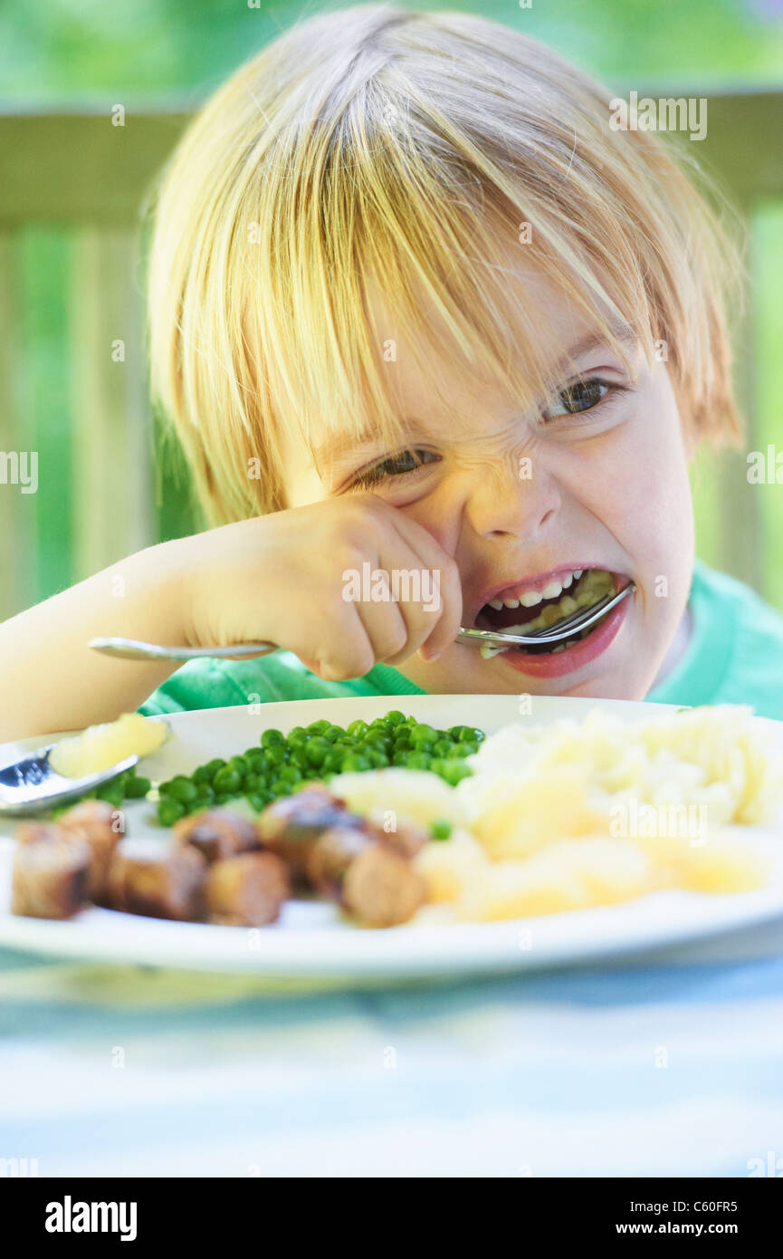 Boy eating vegetables at dinner Stock Photo - Alamy