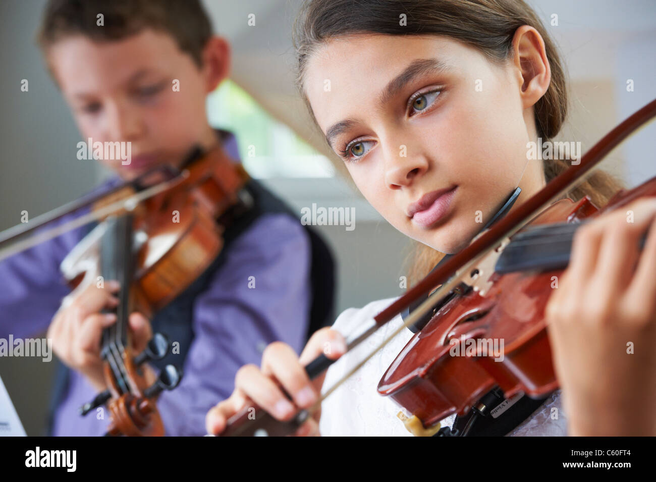 Serious children playing violin Stock Photo - Alamy