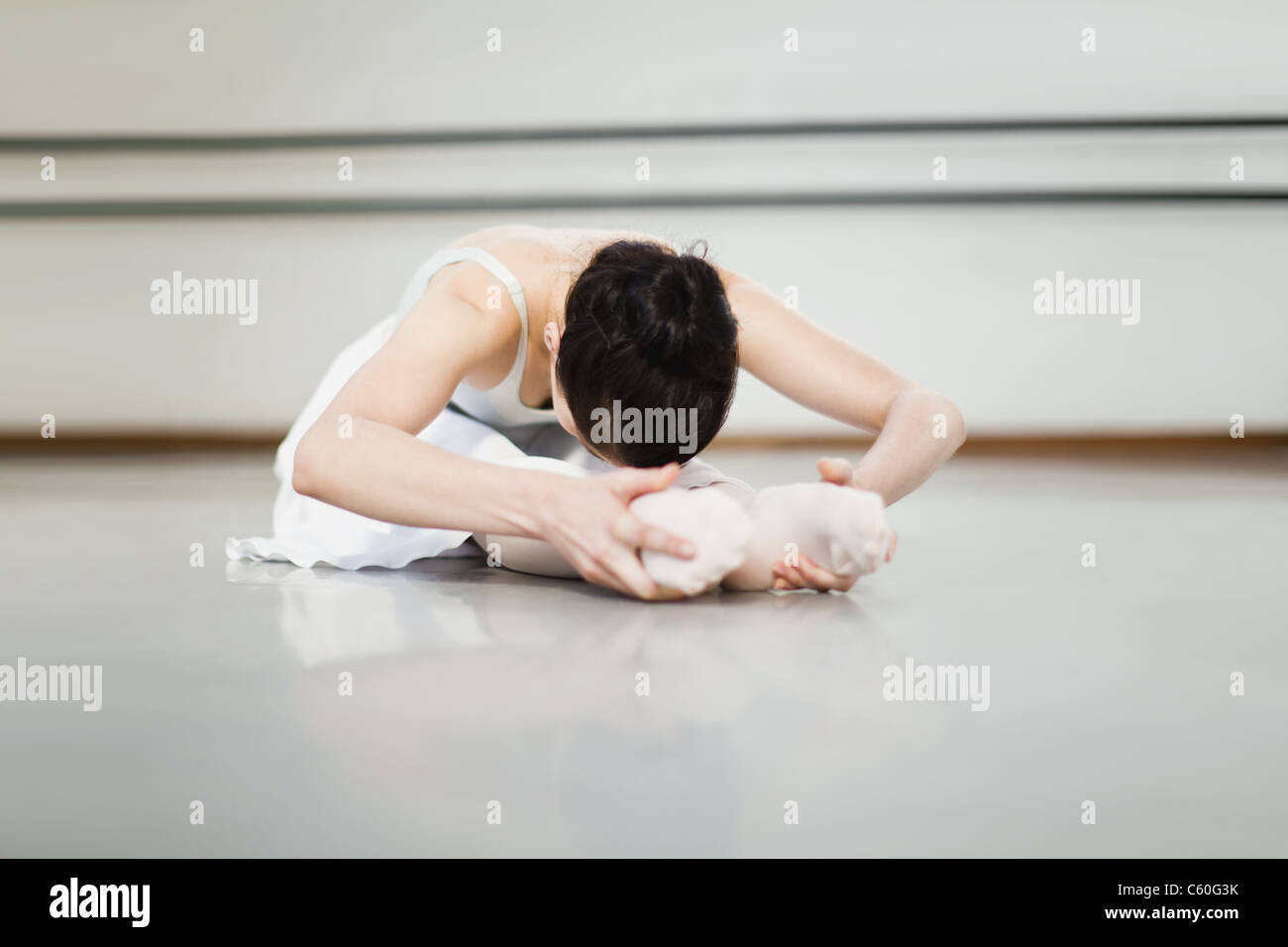Ballet dancer stretching in studio Stock Photo - Alamy