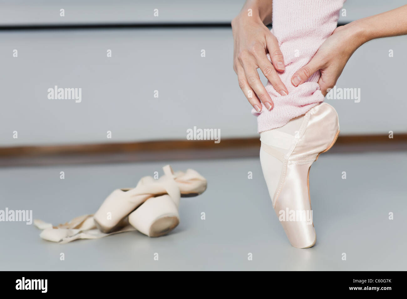 Ballet dancer examining toes on pointe Stock Photo - Alamy