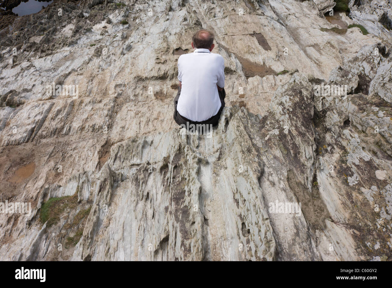 Man sitting on rock from behind hi-res stock photography and images - Alamy