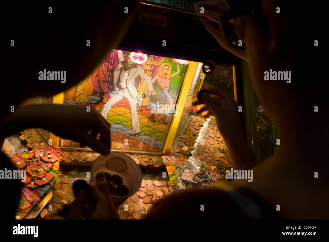 Playing a Penny push/fall game in the amusement arcade at Weston-super ...