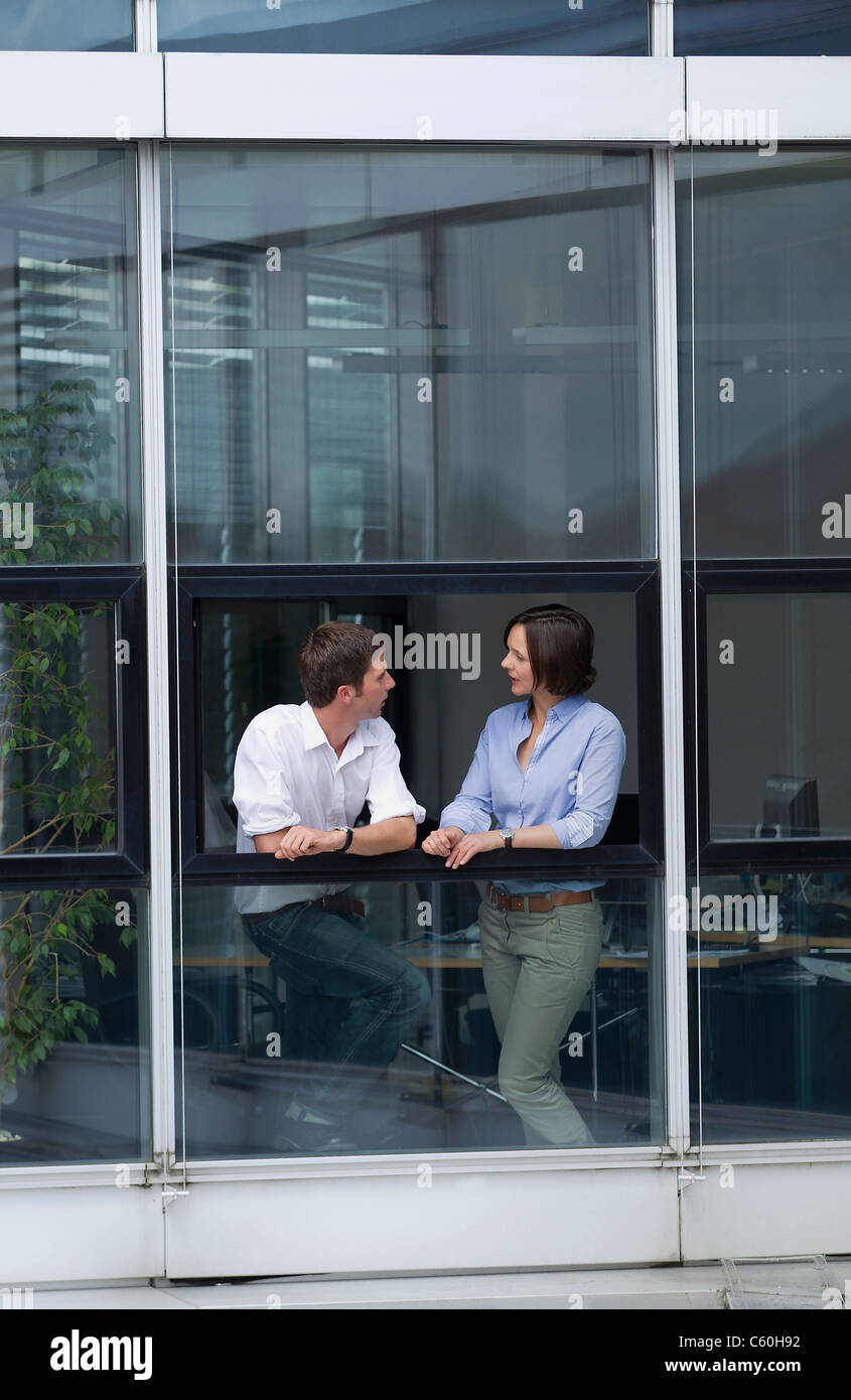 Business people talking at office window Stock Photo - Alamy