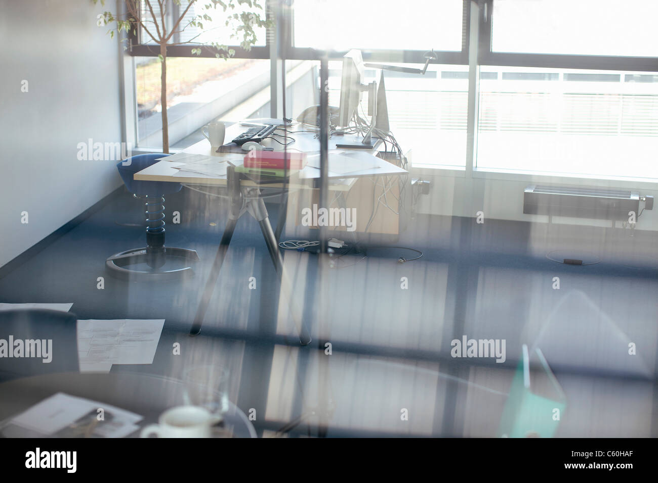 Empty office viewed through window Stock Photo - Alamy