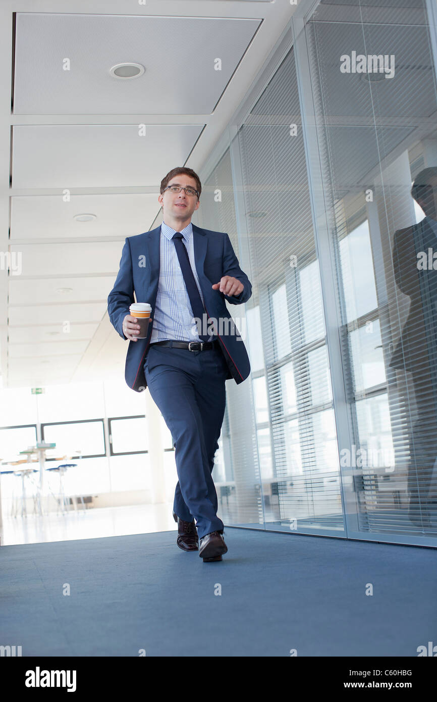 Businessman walking in empty office Stock Photo - Alamy