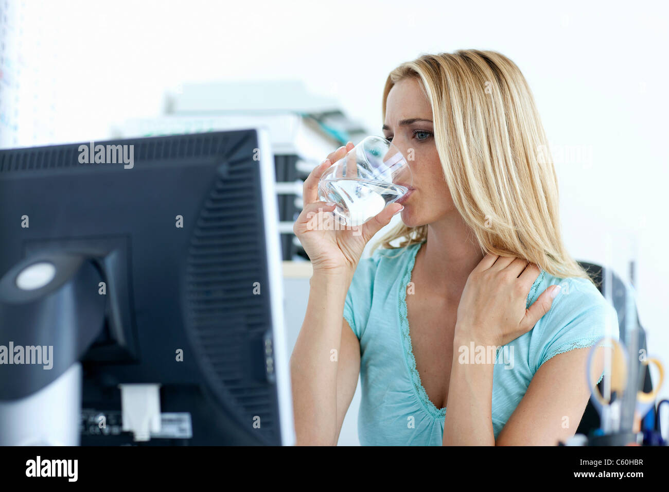 Businesswoman drinking water at desk Stock Photo - Alamy