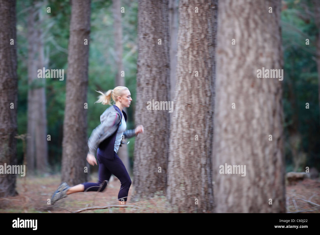 Woman running in forest Stock Photo - Alamy