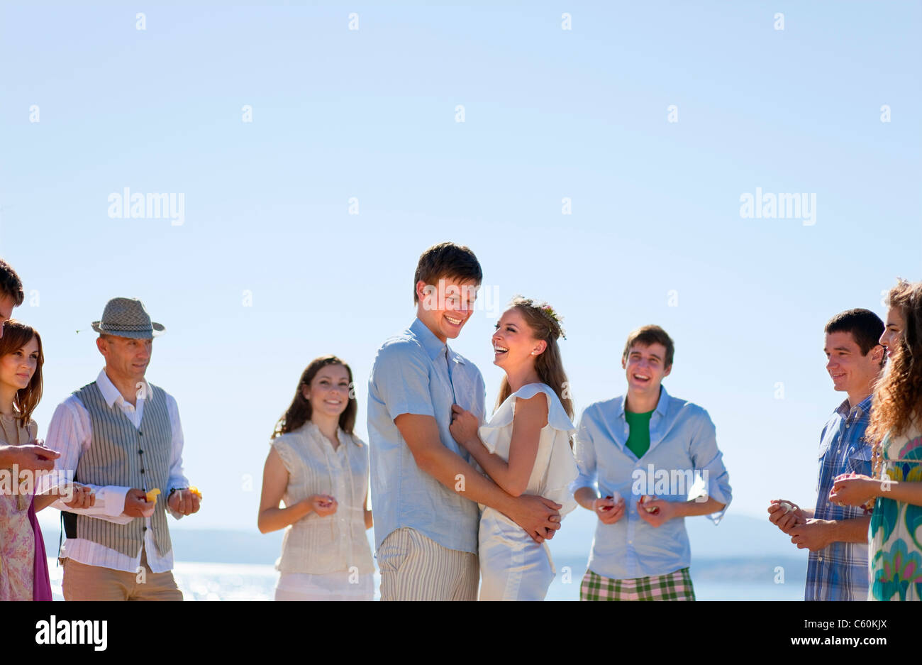 Bride and groom surrounded by friends Stock Photo - Alamy