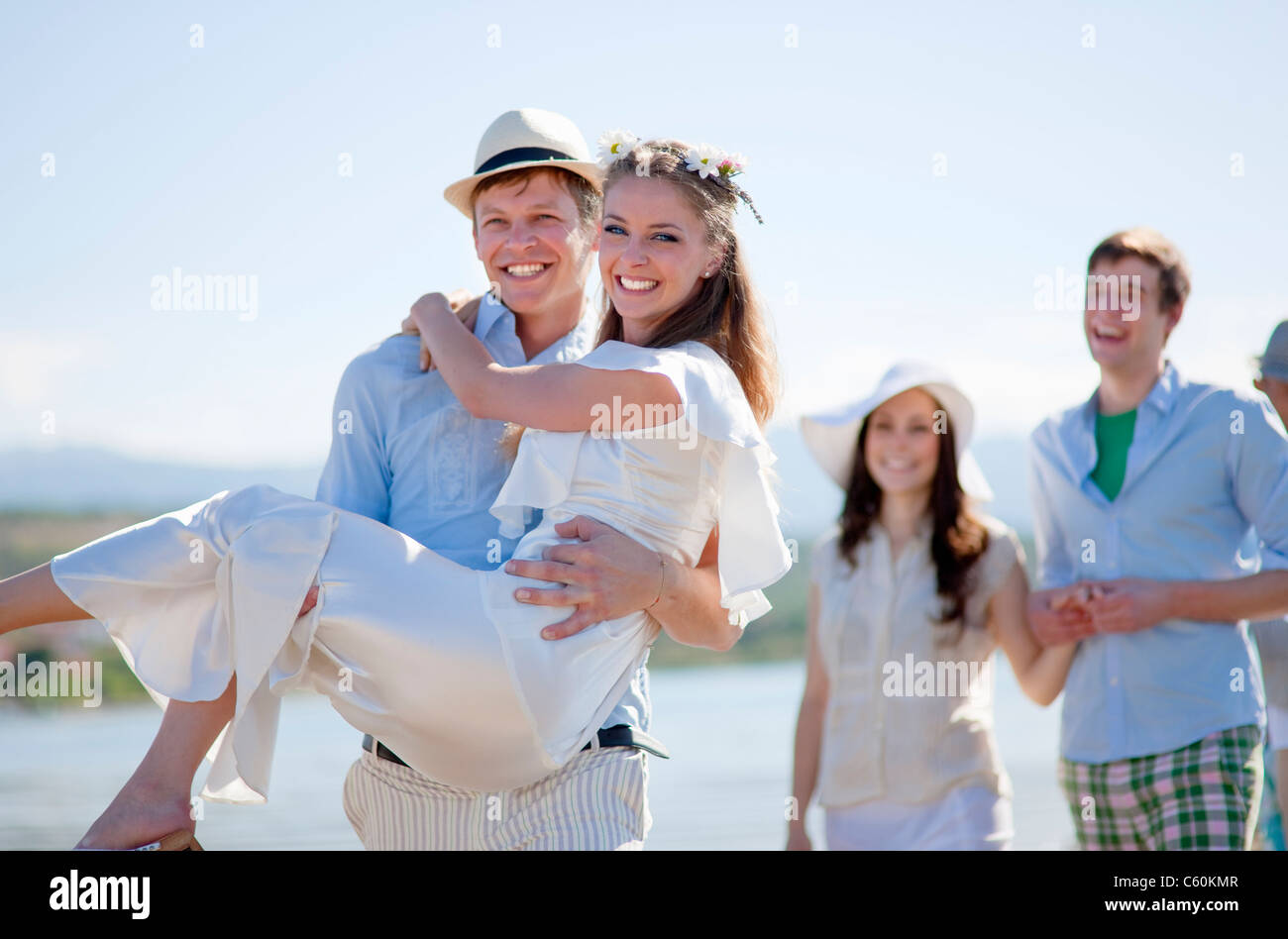 Groom carrying bride outdoors Stock Photo - Alamy