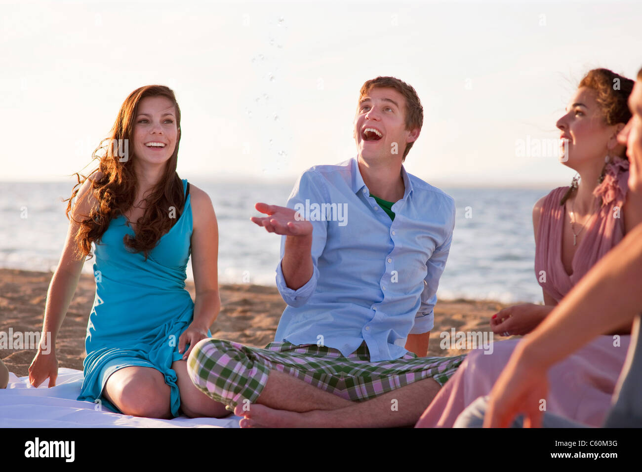People relaxing together on beach Stock Photo - Alamy