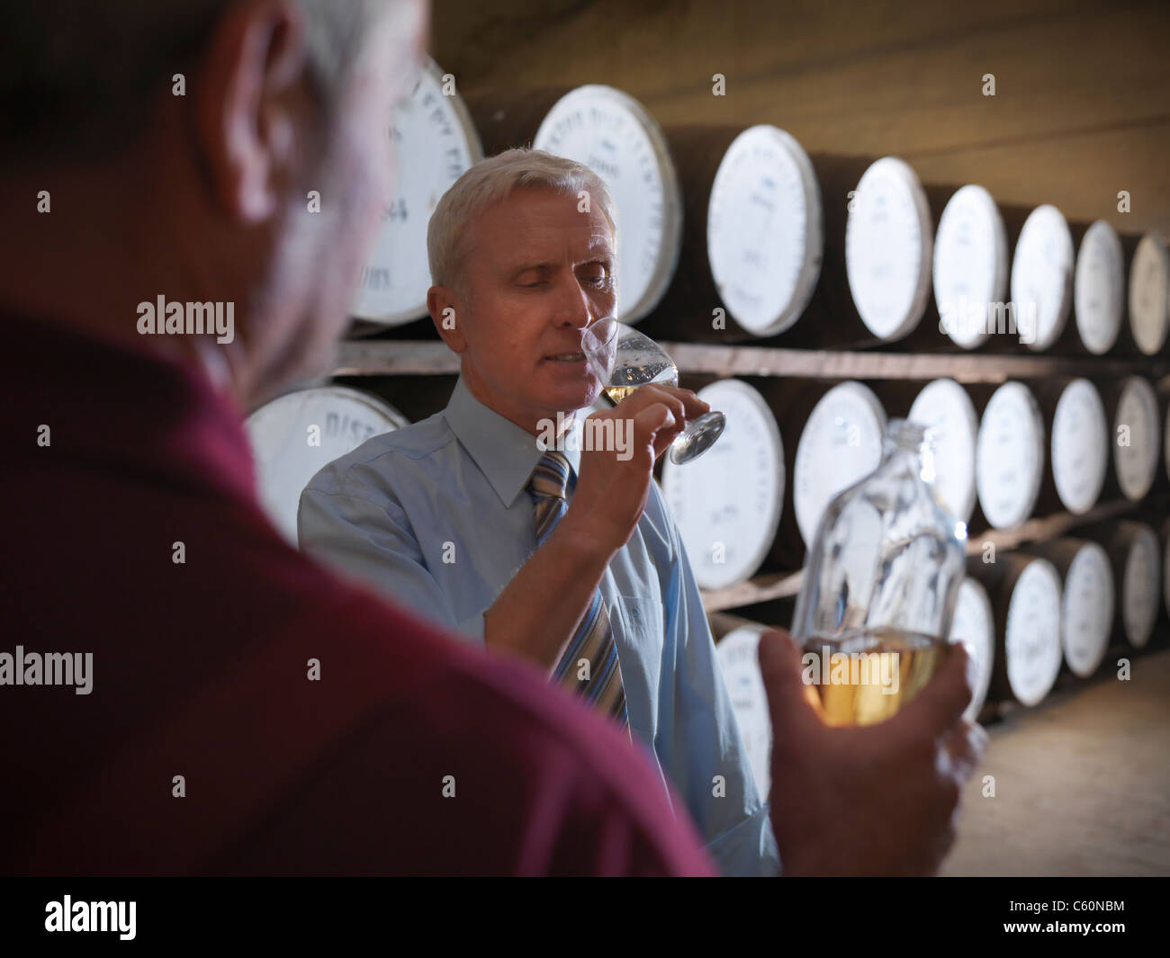 Workers checking whisky in distillery Stock Photo - Alamy