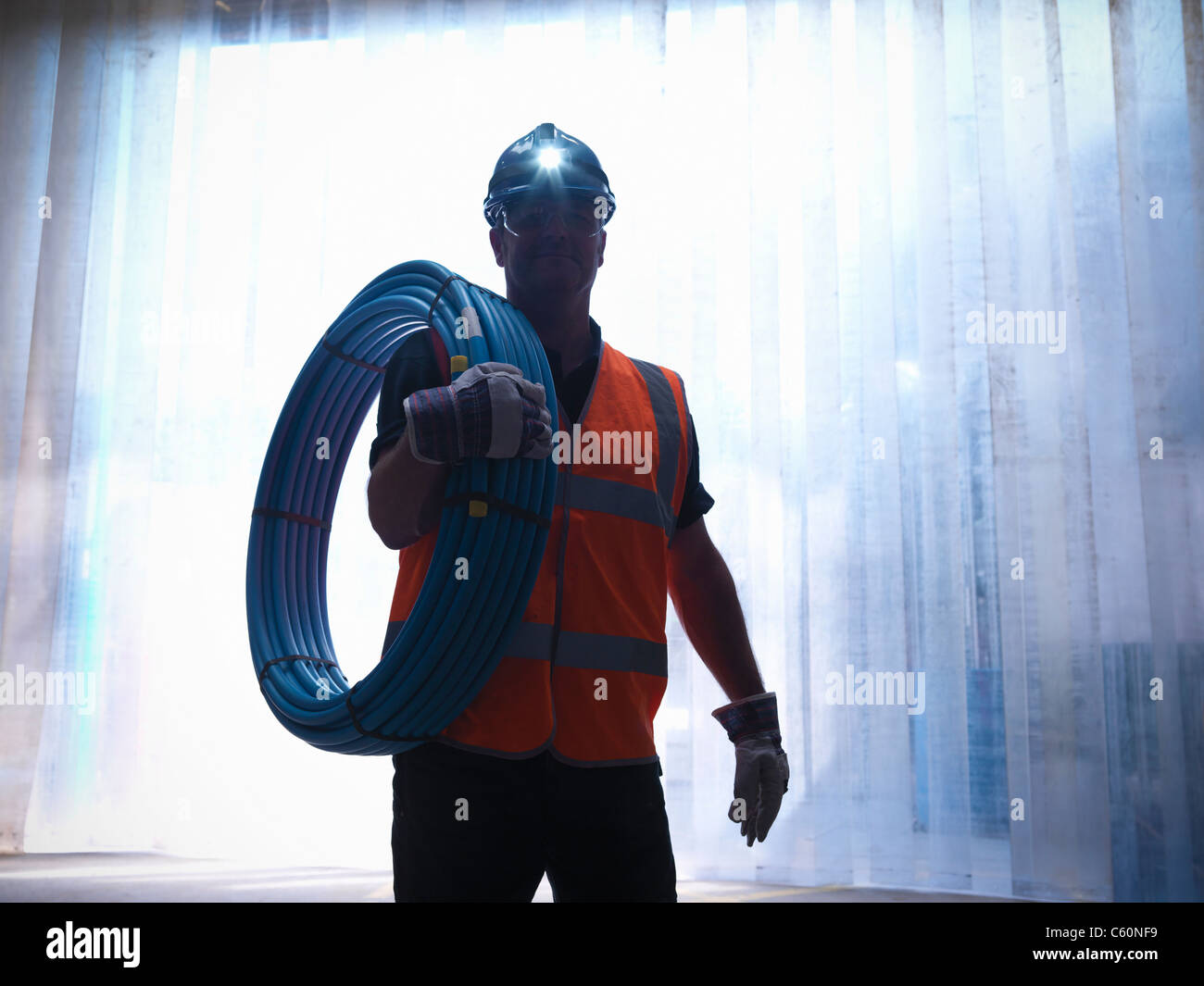 Worker carrying water pipes Stock Photo - Alamy