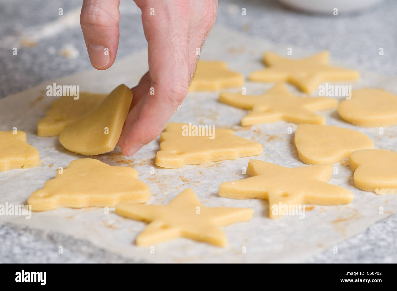 Placing star and heart shape cookies after cutting on backing paper ...