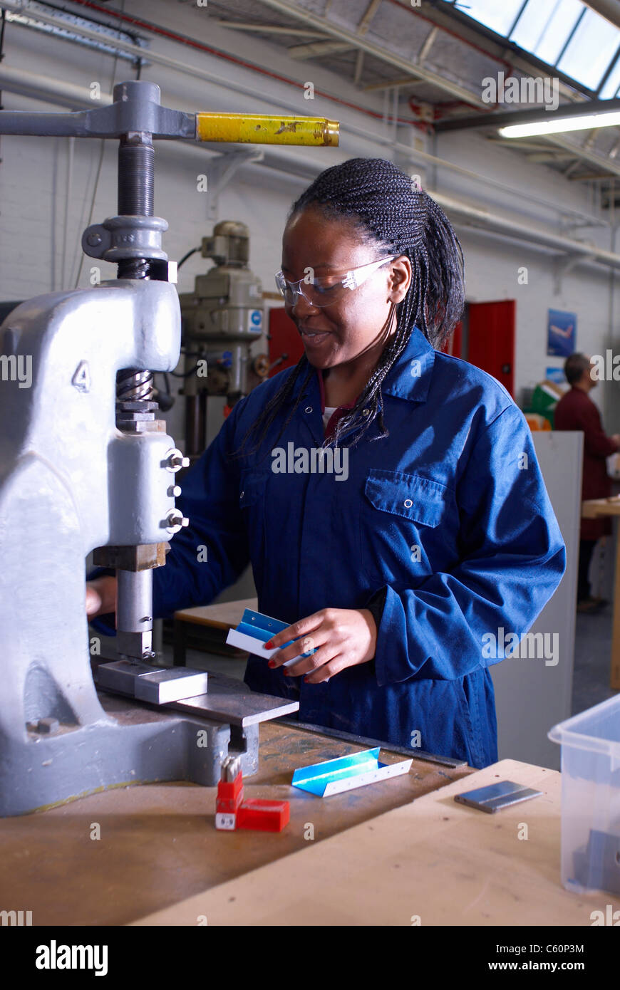 Worker using drill in factory Stock Photo - Alamy