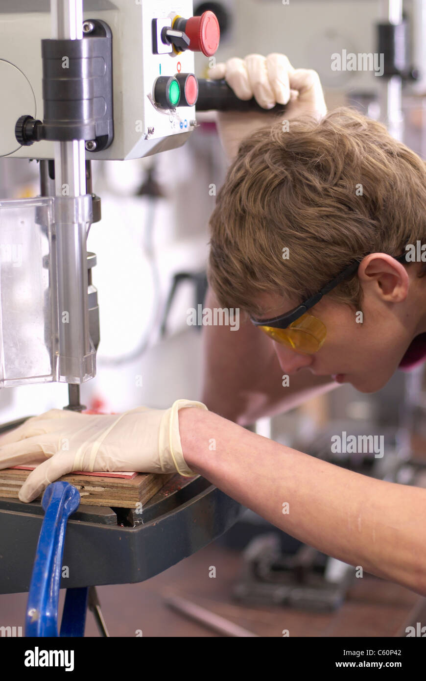 Worker using drill in factory Stock Photo - Alamy