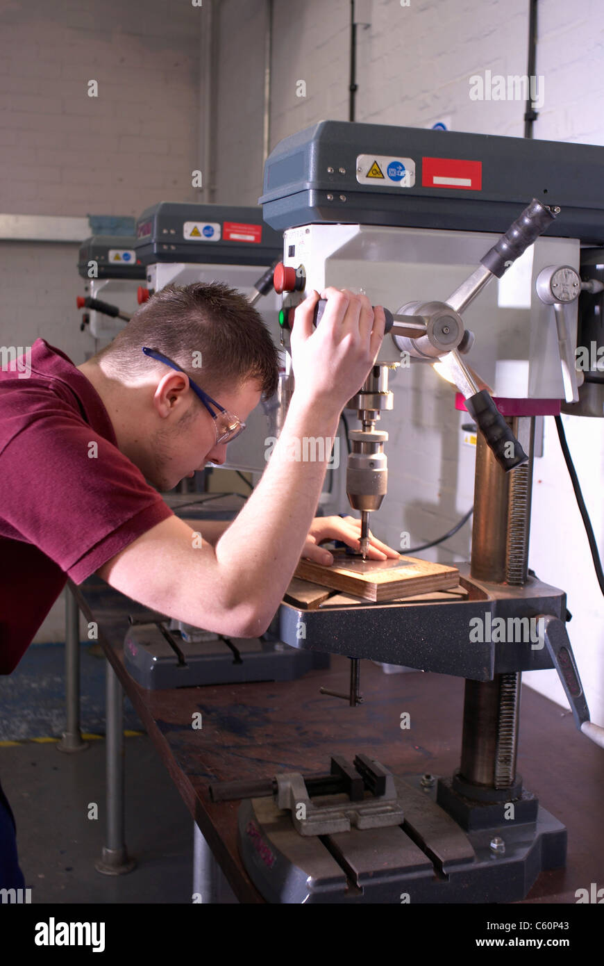 Worker using drill in factory Stock Photo - Alamy