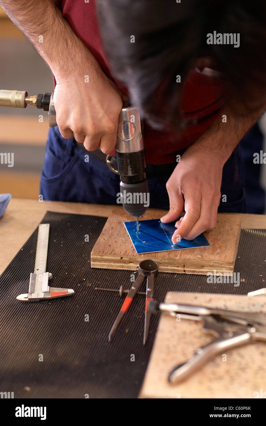 Worker using drill in factory Stock Photo - Alamy