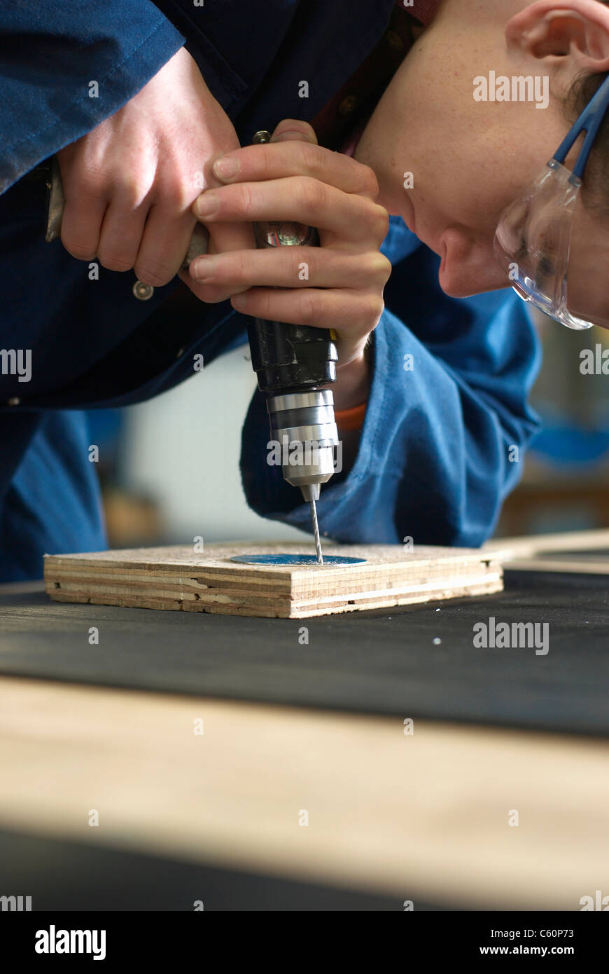 Worker using drill in factory Stock Photo - Alamy