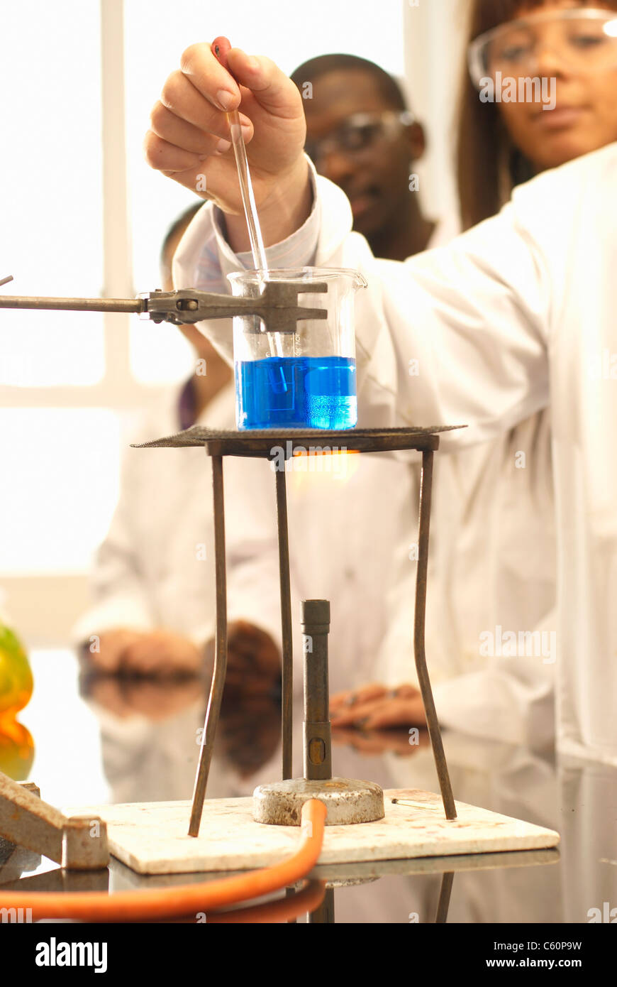 Scientist adding solution to beaker Stock Photo - Alamy