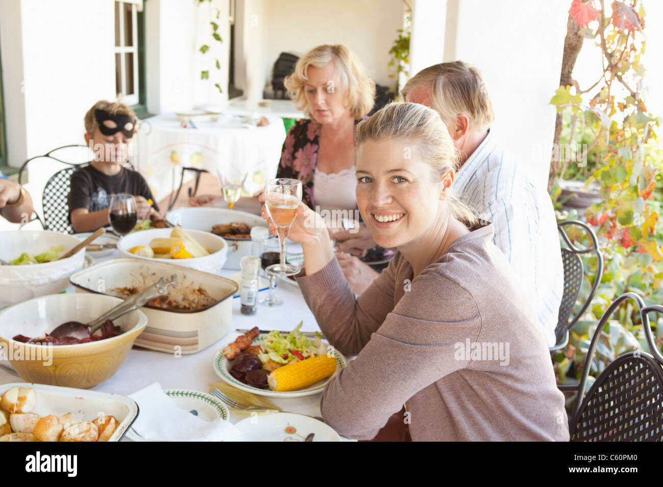 Family eating at table outdoors Stock Photo - Alamy