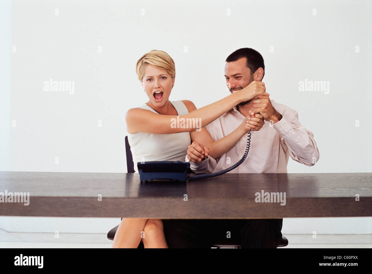 Business people fighting over telephone Stock Photo - Alamy