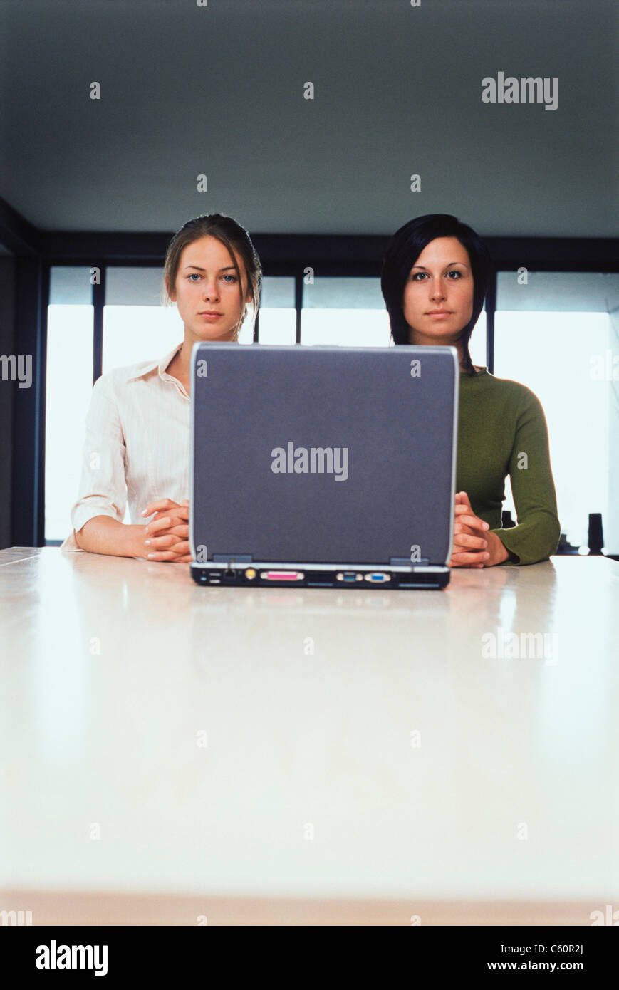 Businesswomen using laptop together Stock Photo - Alamy
