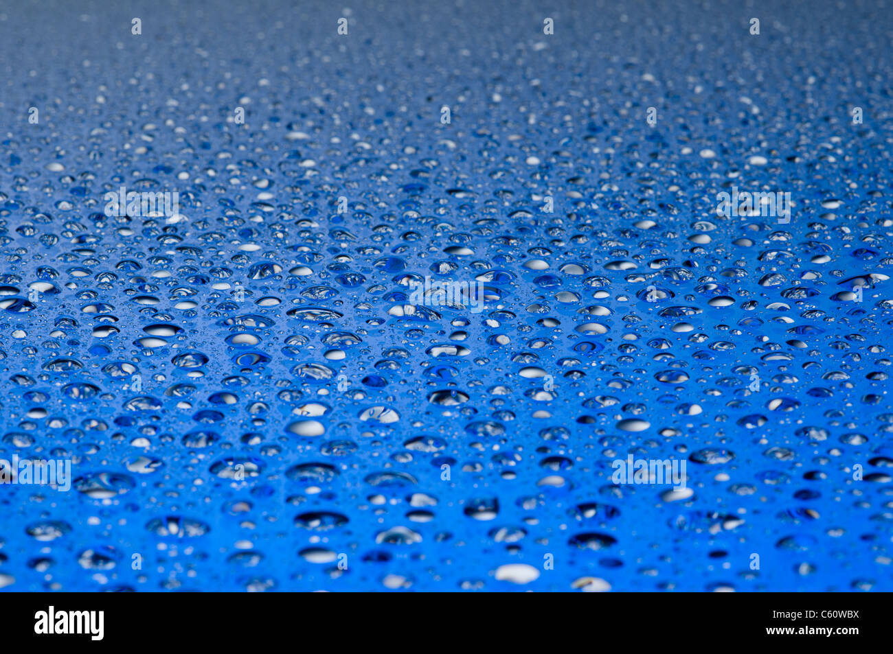 Water drops on a shiny surface in blue Stock Photo - Alamy
