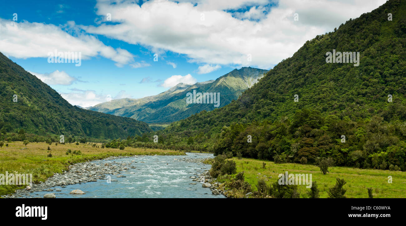 river flowing through a valley with mountain massive in the back ground ...