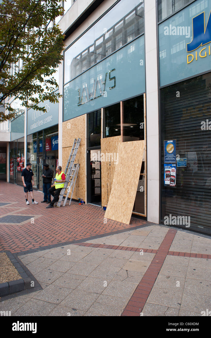 A shop repairs the damage after the riots took place in Birmingham ...