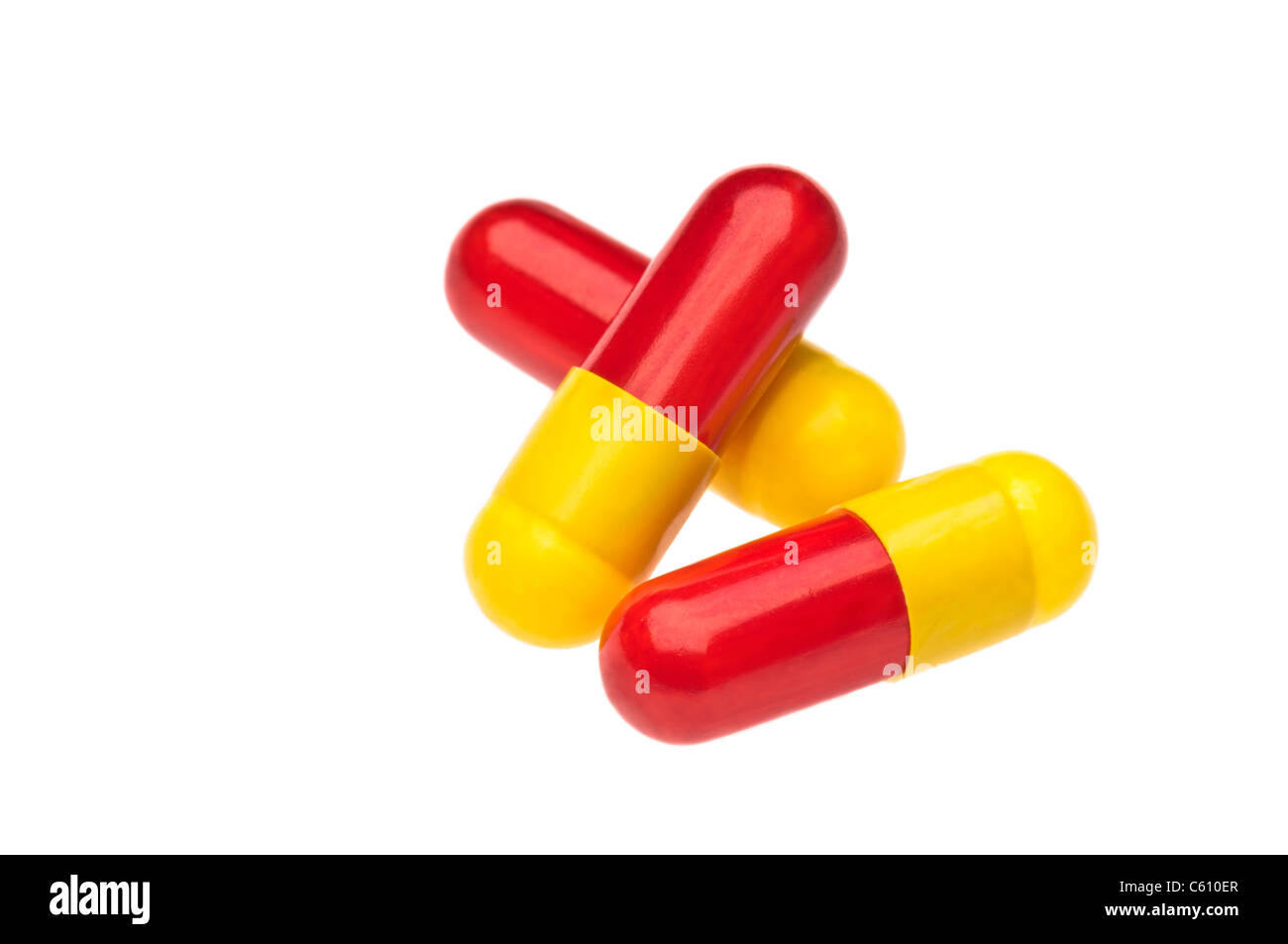 Three red yellow capsules over white two as a stack Stock Photo - Alamy