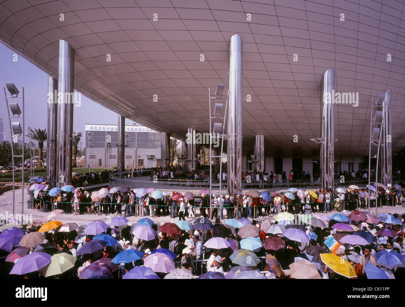 Long line of people with umbrella's against the sunlight in front of ...