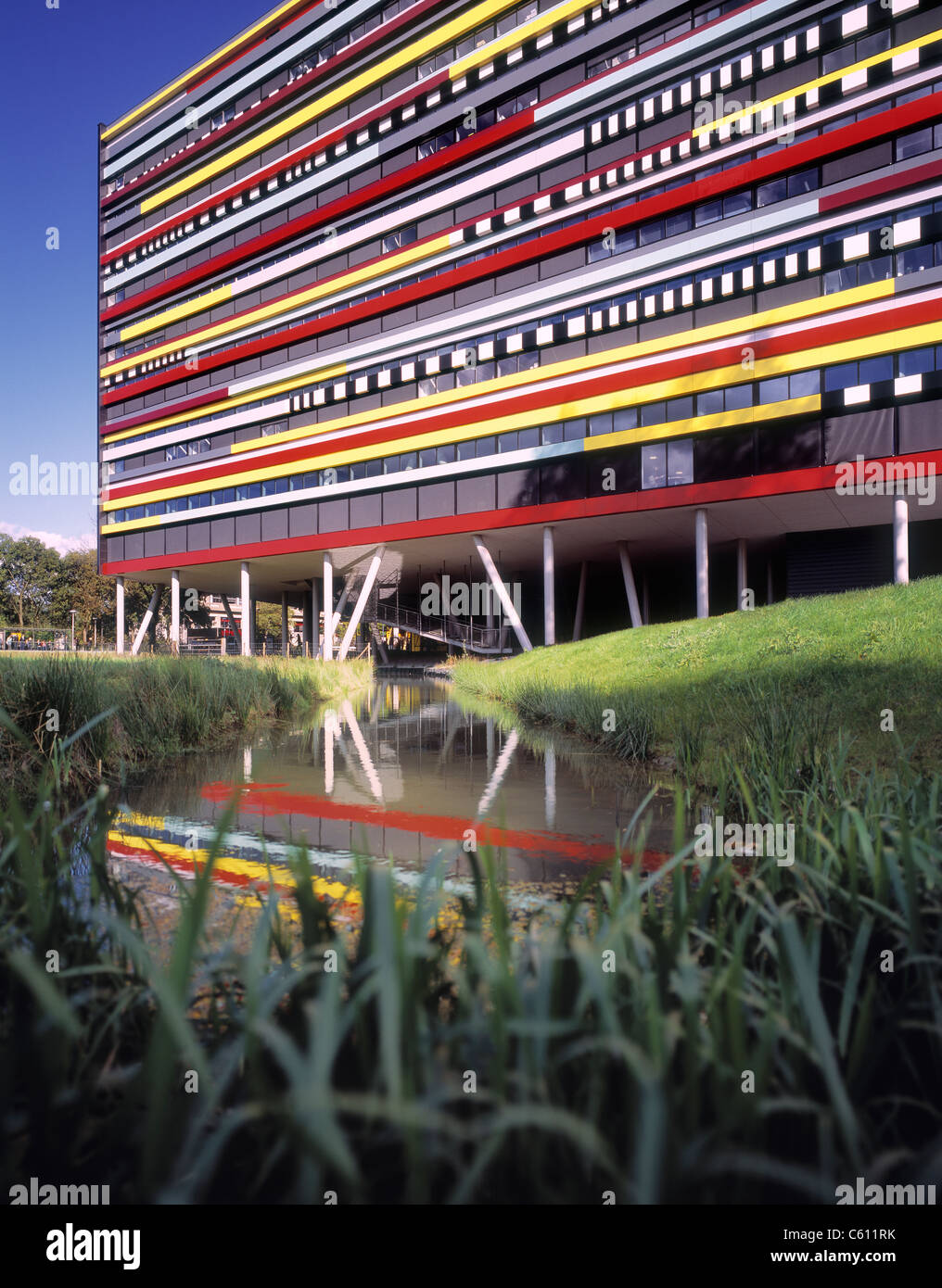 Colorful modern office building reflecting in water Stock Photo - Alamy