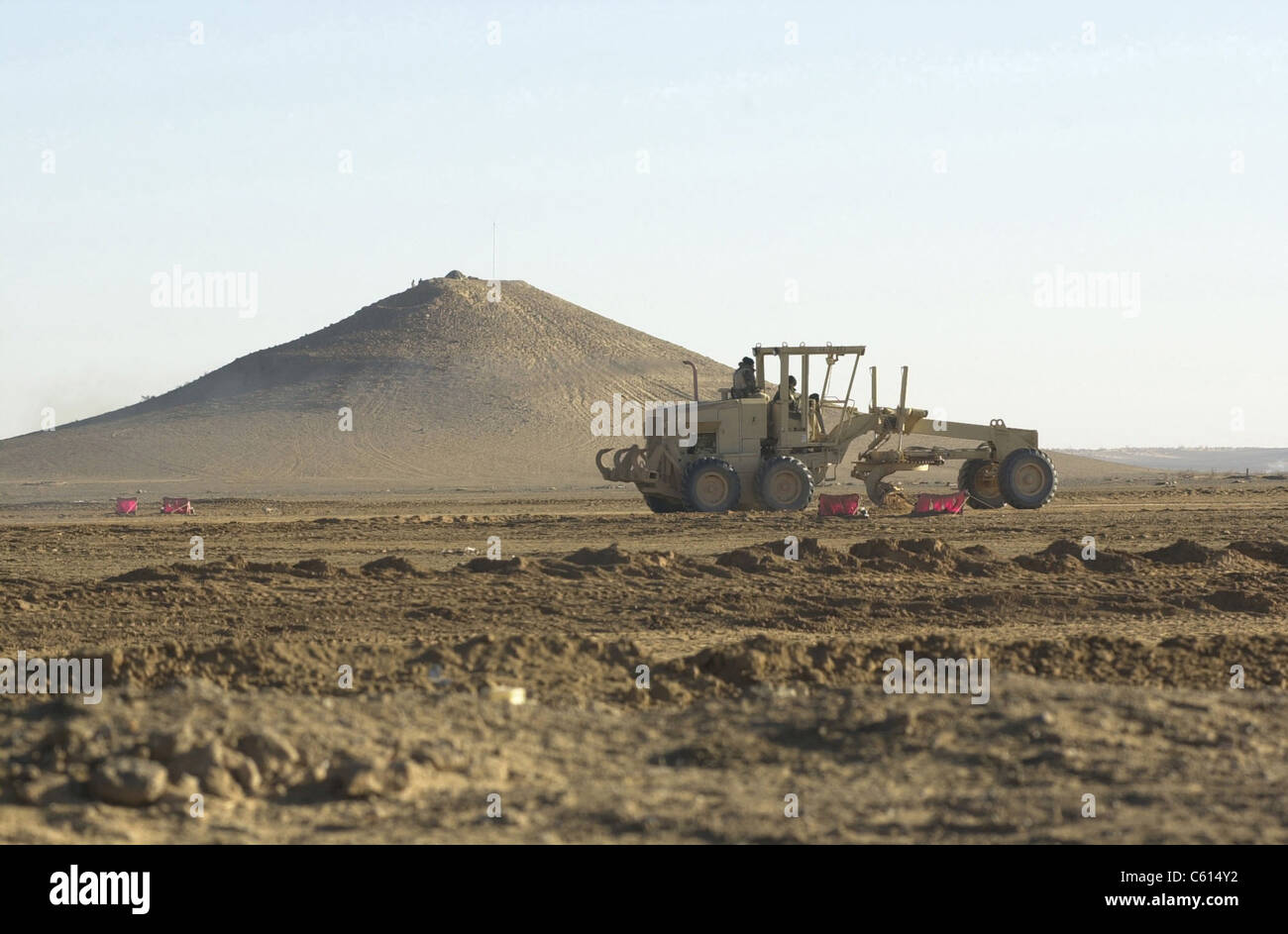 U.S. Navy Seabees run heavy graders down the runway to patch holes and ...