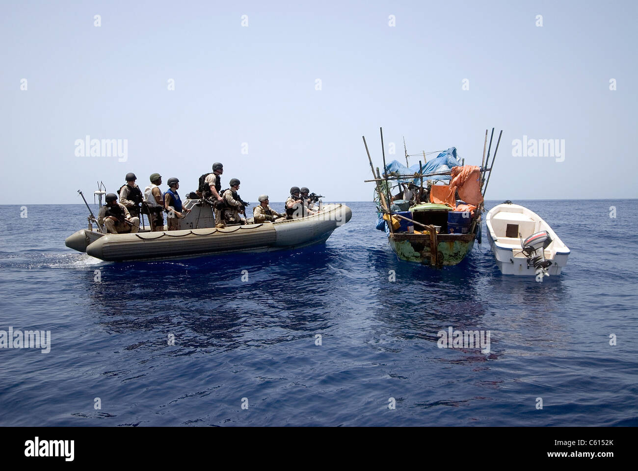 U.S. Navy and Coast Guard counter piracy personnel approach a suspect ...