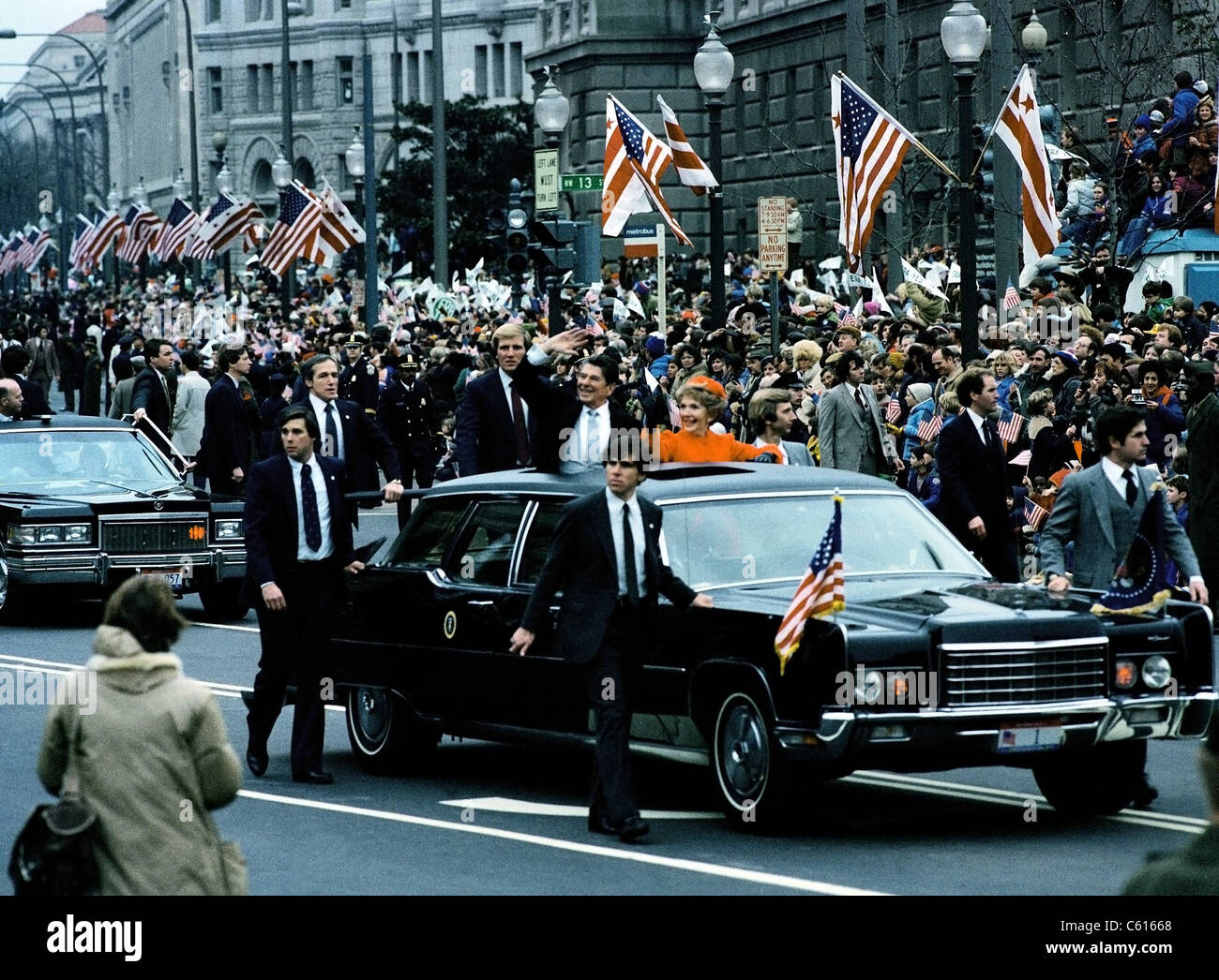 President and Mrs. Reagan wave to crowds as they ride in the ...