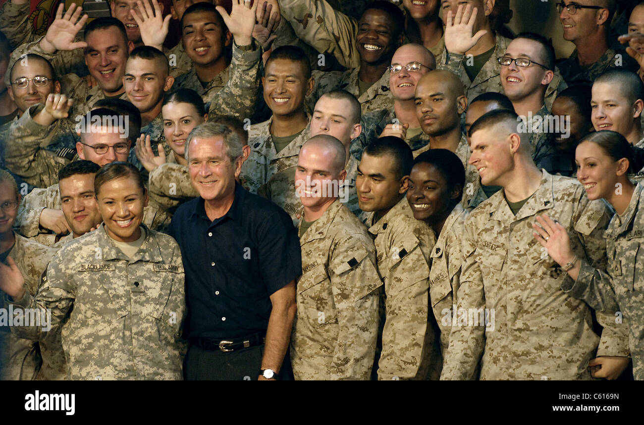 US soldiers gather around President George W. Bush during a visit to Al ...