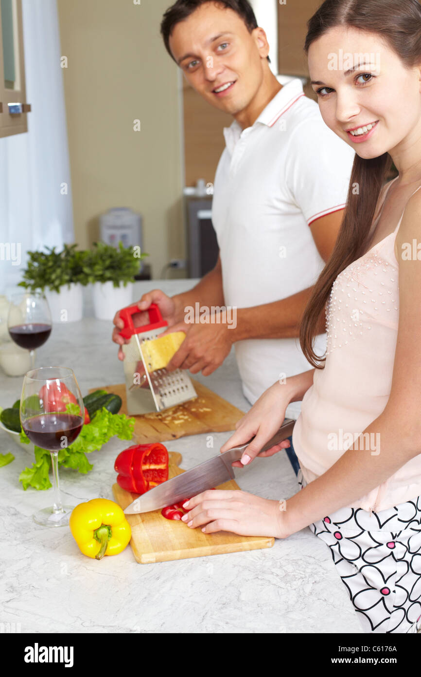 Portrait of amorous couple cooking salad in the kitchen Stock Photo - Alamy