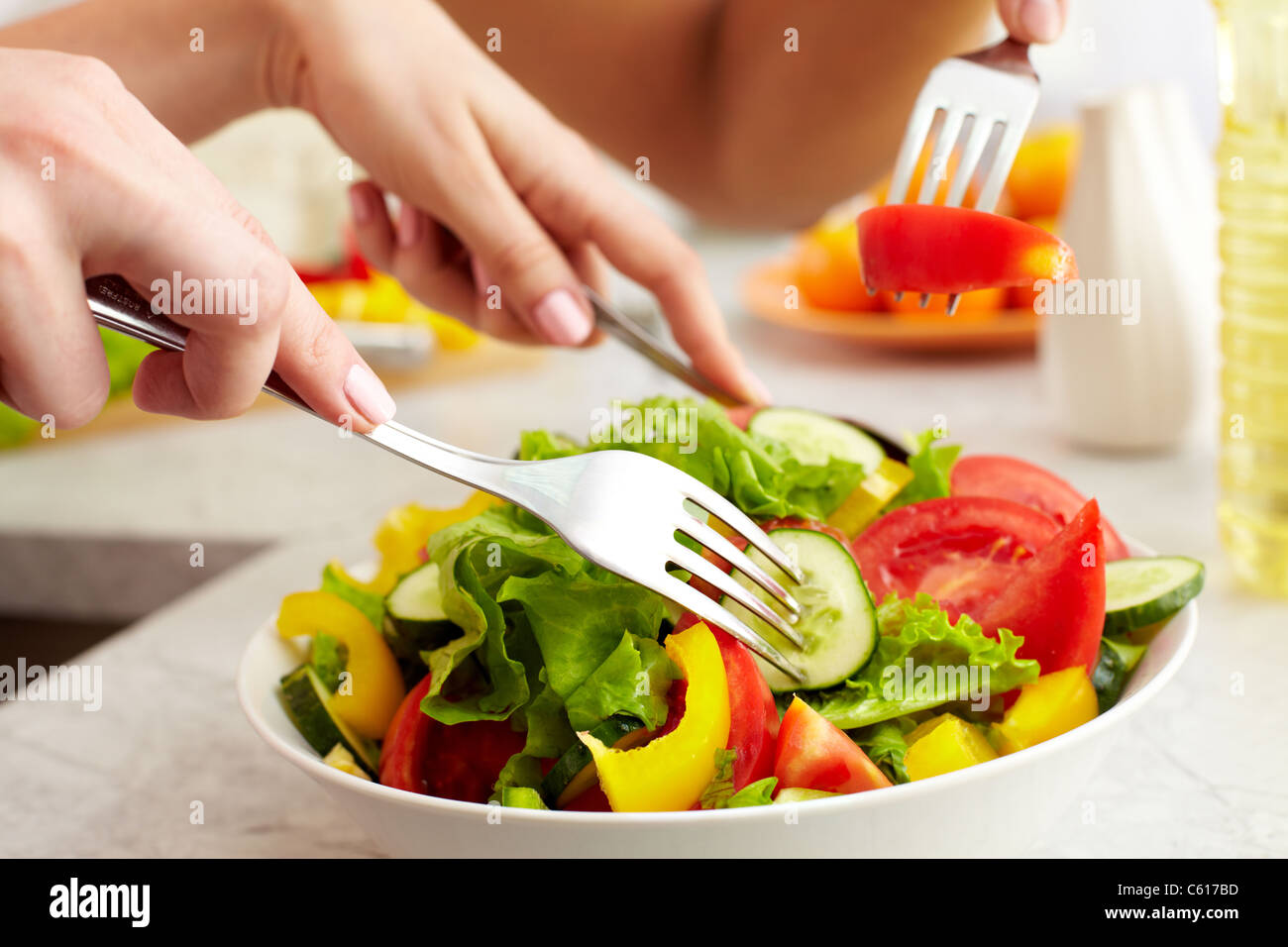 Close-up of human hands with forks tasting salad Stock Photo - Alamy