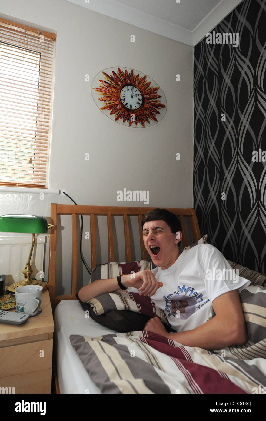 Lazy teenage boy wakes up early in the afternoon still in bed Stock ...