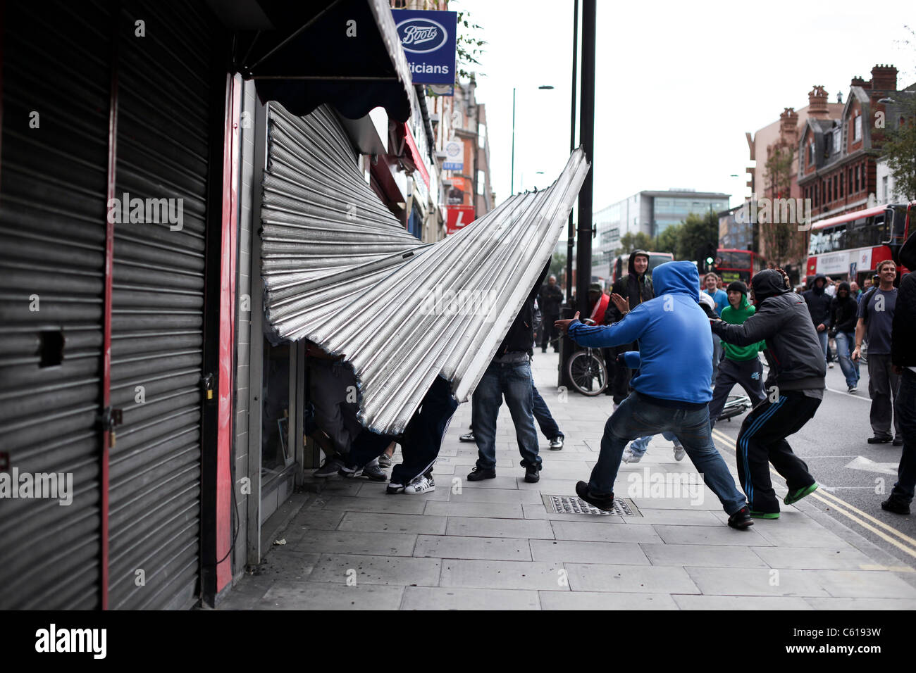 Looters force their way into a shop in Hackney street riots, London ...