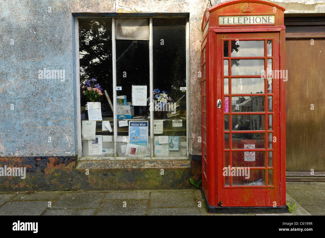 Red telephone box outside the closed general store in the Welsh village ...