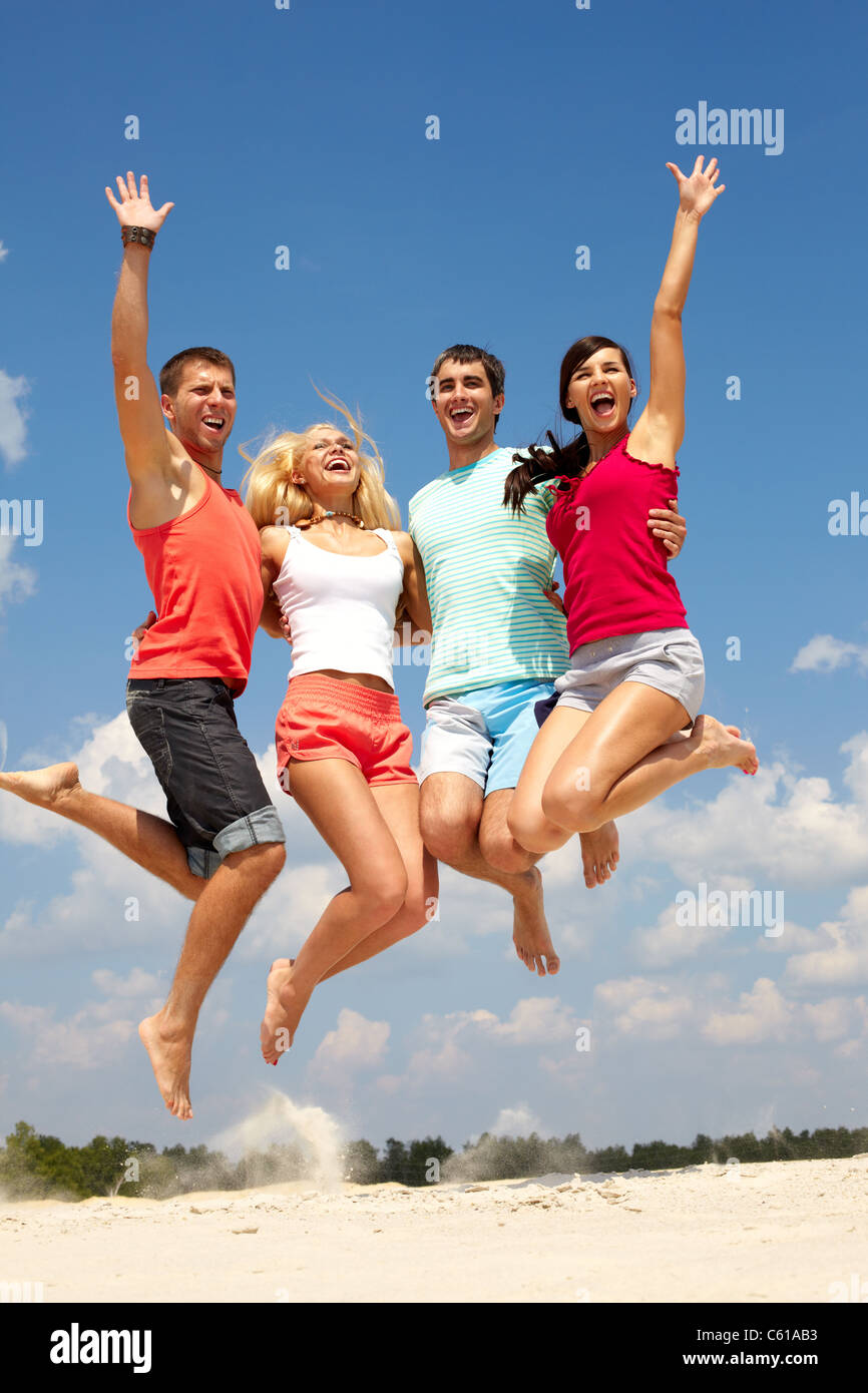 Portrait of four jumping happy people Stock Photo - Alamy