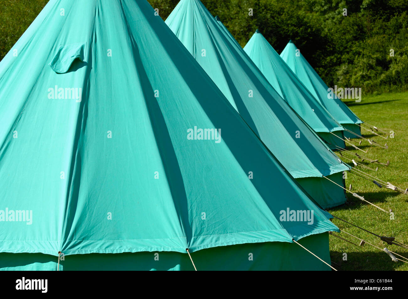 A row of green Bell tents made from heavy canvas and secured to the ...