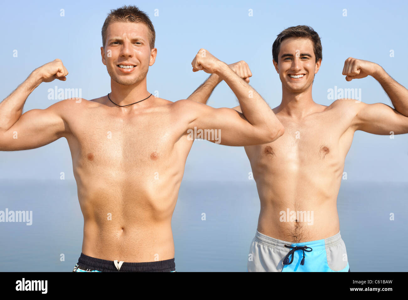 Two happy guys showing their muscles Stock Photo - Alamy
