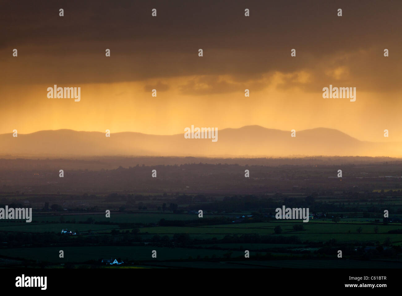 A rain storm at dusk over the Malvern Hills viewed from the Cotswold ...
