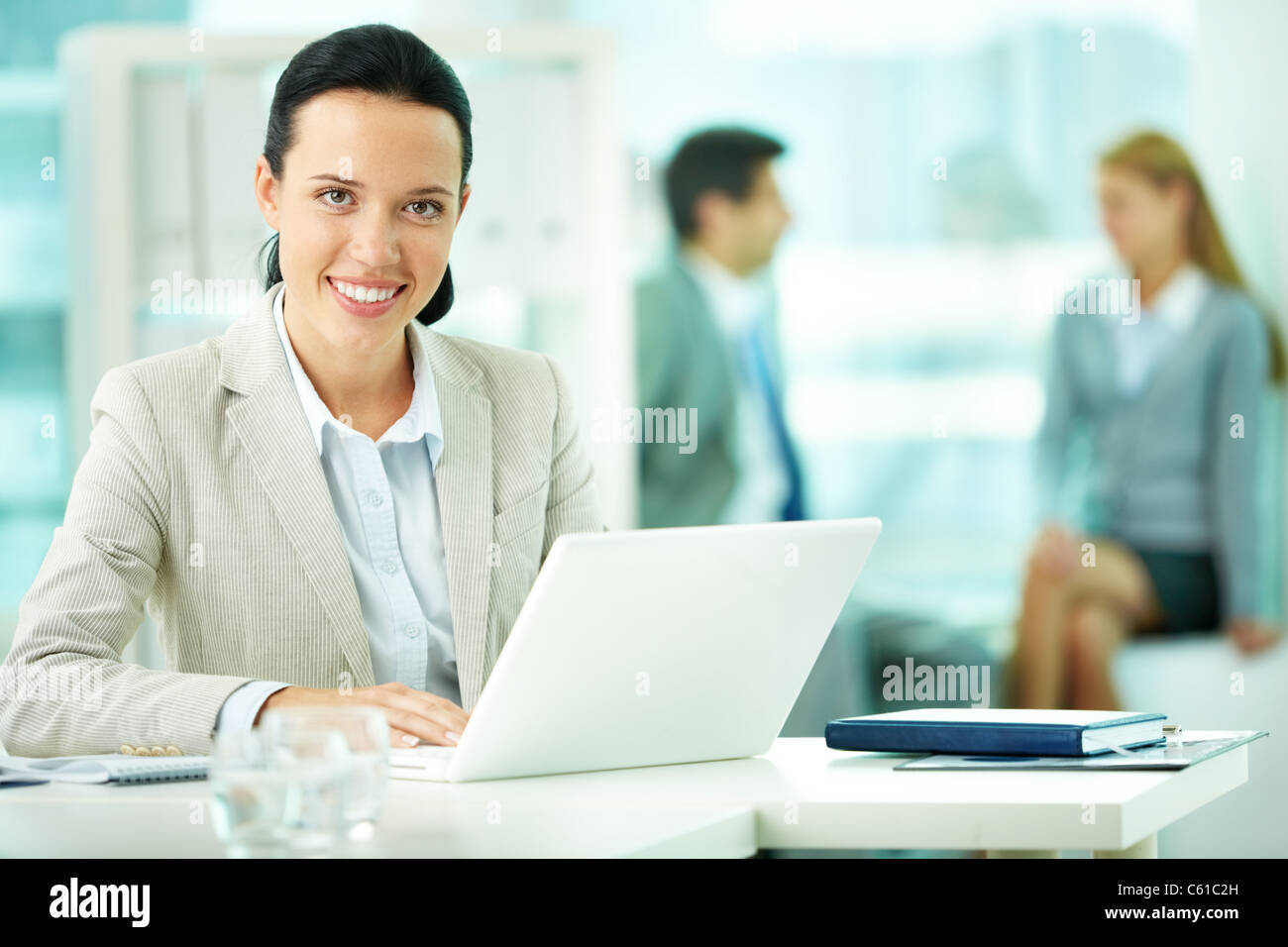 Portrait of pretty secretary working with her partners on background ...
