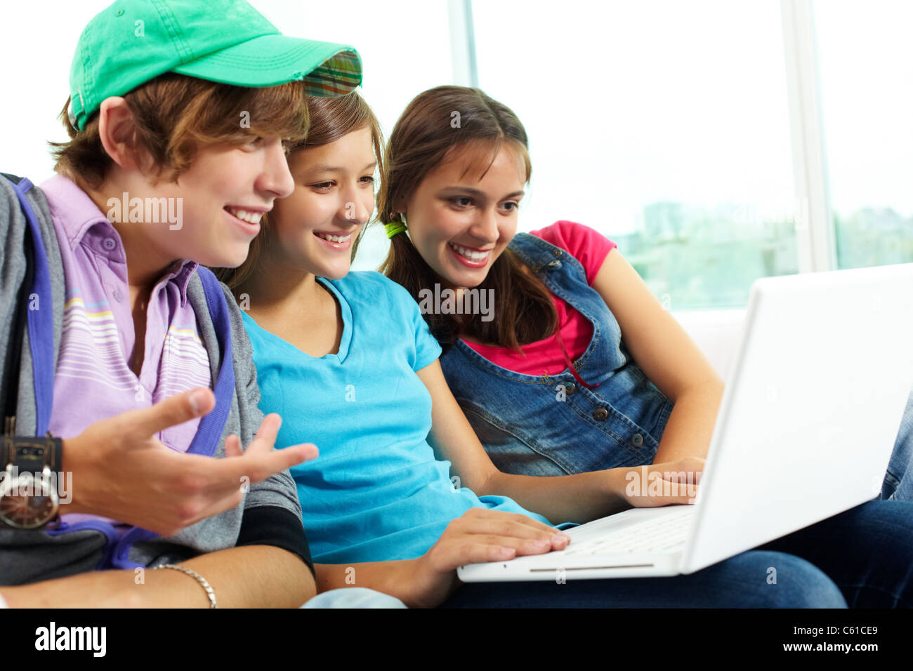 Three teenagers looking at laptop screen Stock Photo - Alamy